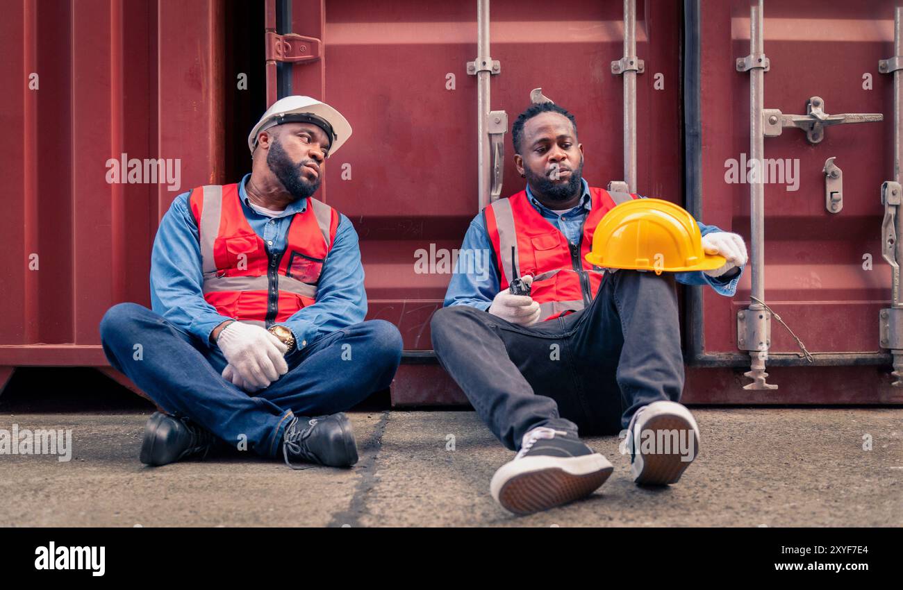Two Engineer or foreman wears PPE sitting stress on container ...