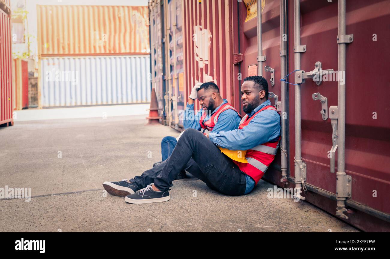 Two Engineer or foreman wears PPE sitting stress on container ...