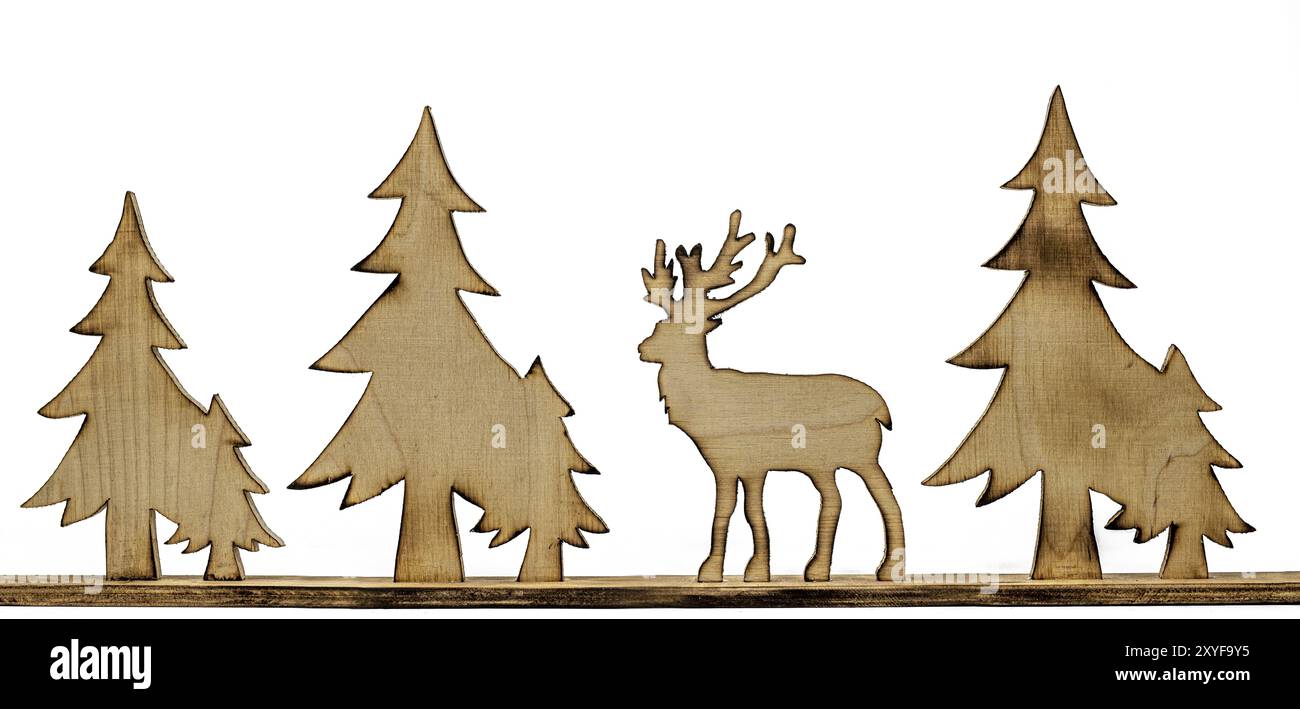 Deer figure sawn out of wood with dark edges and wooden fir trees cut ...