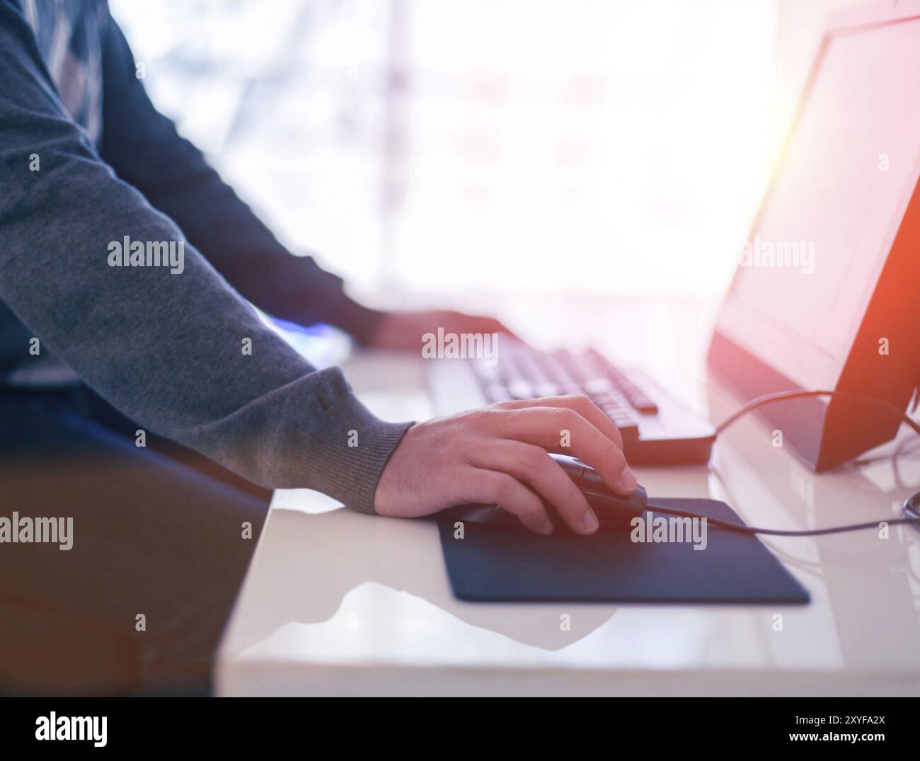 Male hand holding computer mouse with laptop keyboard in the background ...