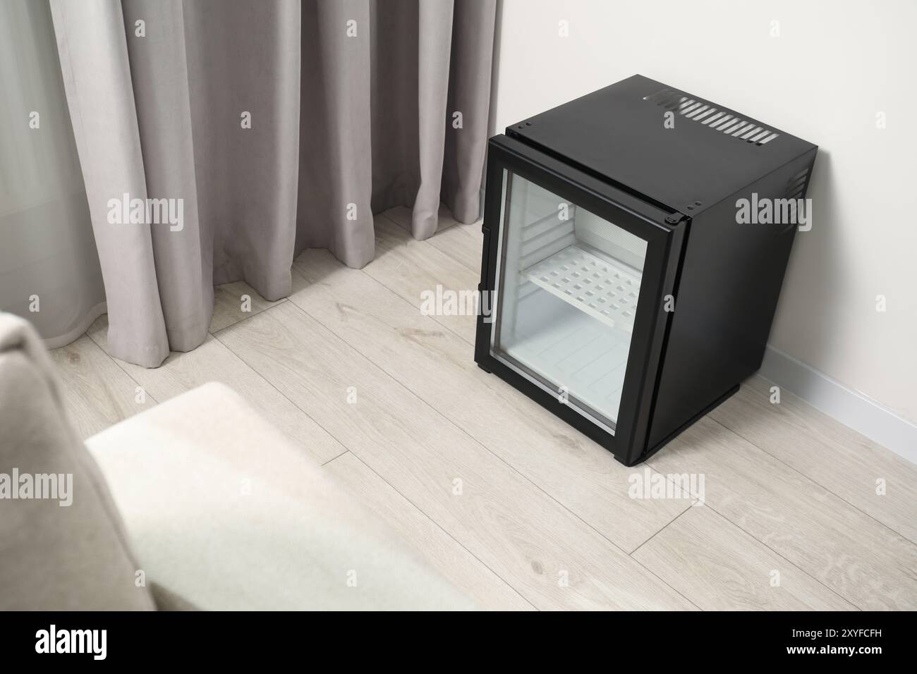 Empty modern mini refrigerator on floor indoors Stock Photo - Alamy