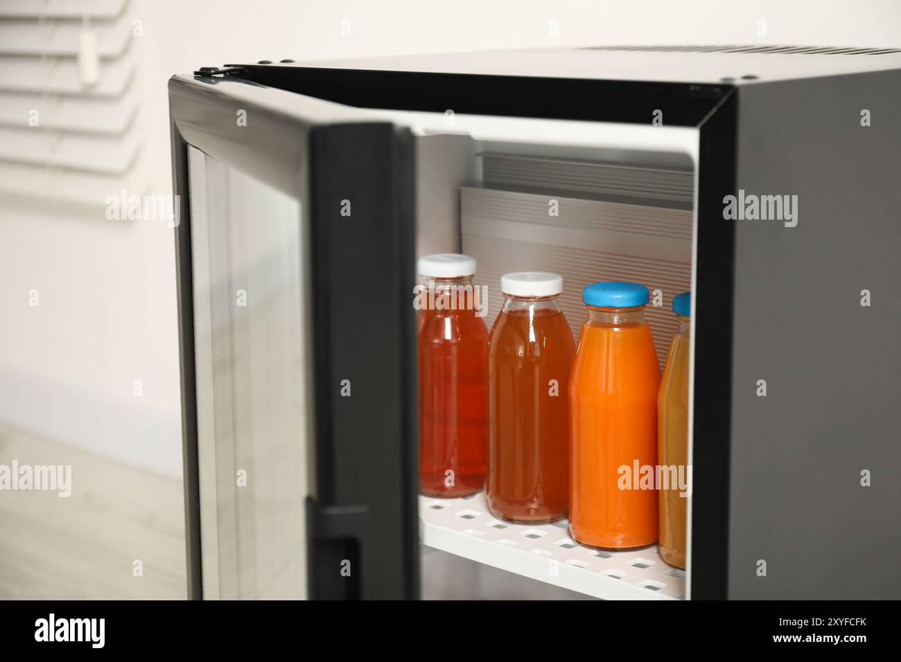 Open mini refrigerator with different drinks indoors Stock Photo - Alamy