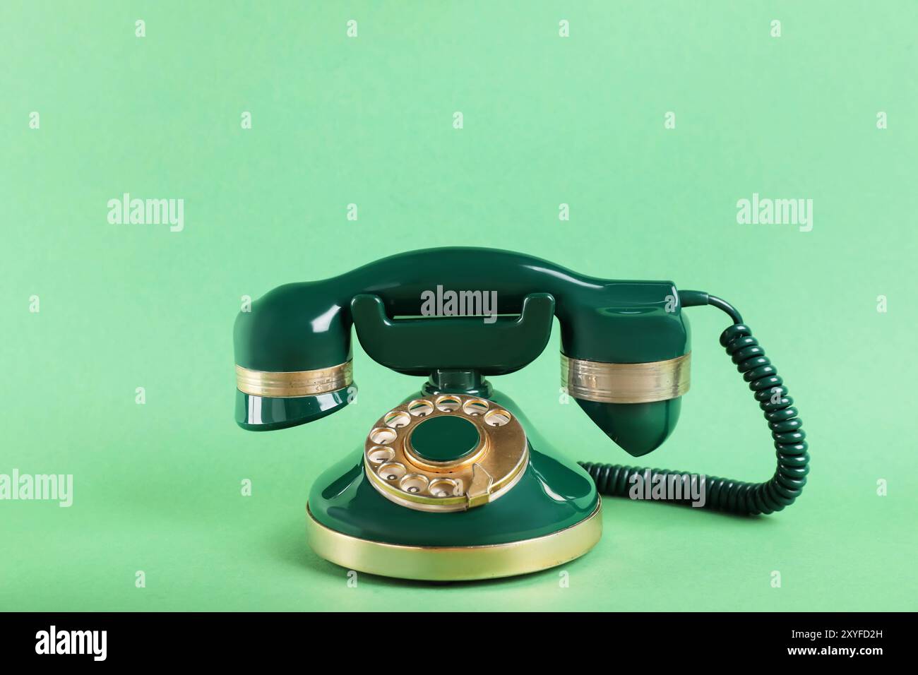 One telephone with handset on green background Stock Photo - Alamy