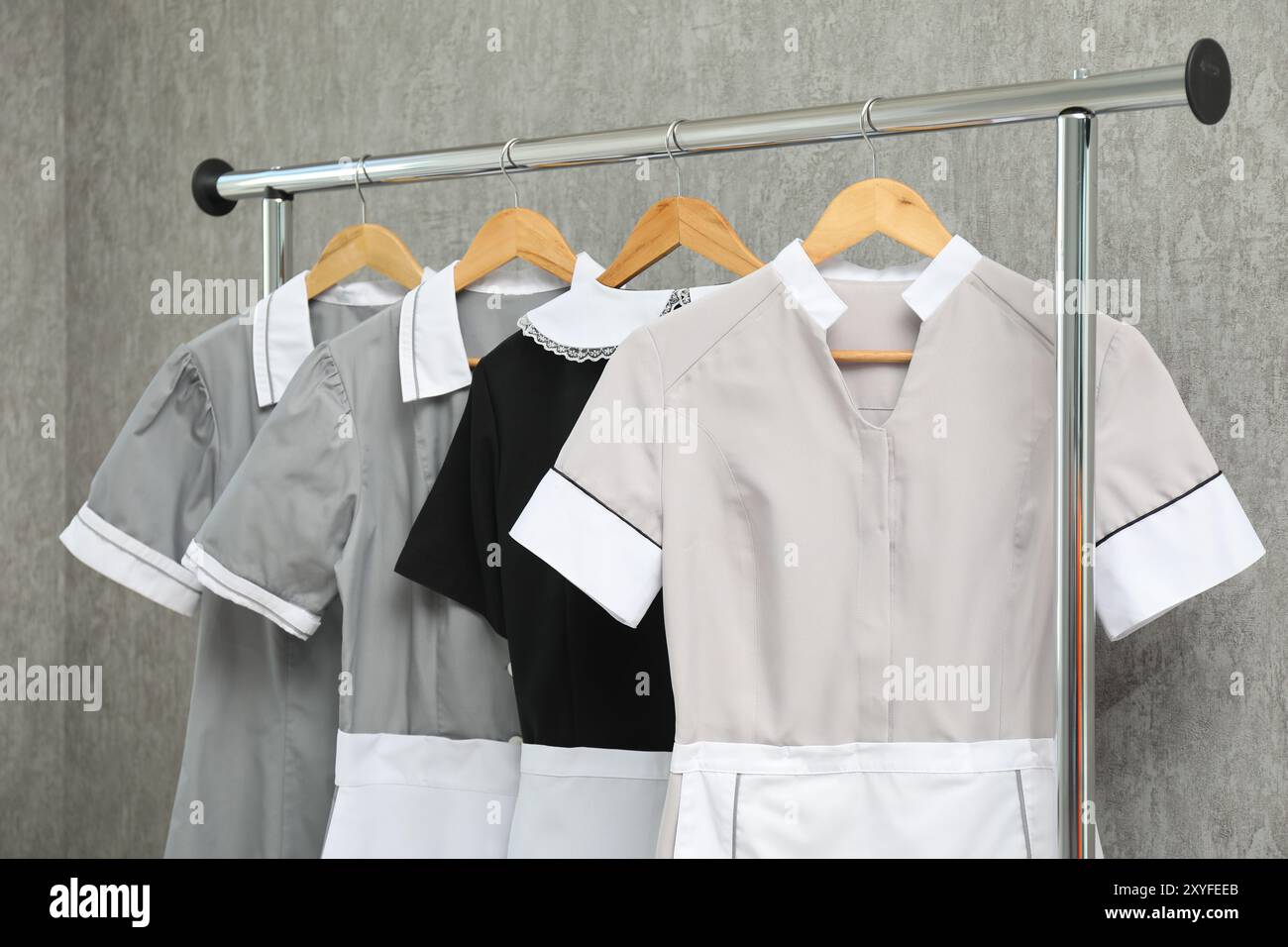 Maids' uniforms on clothing rack near grey wall Stock Photo - Alamy