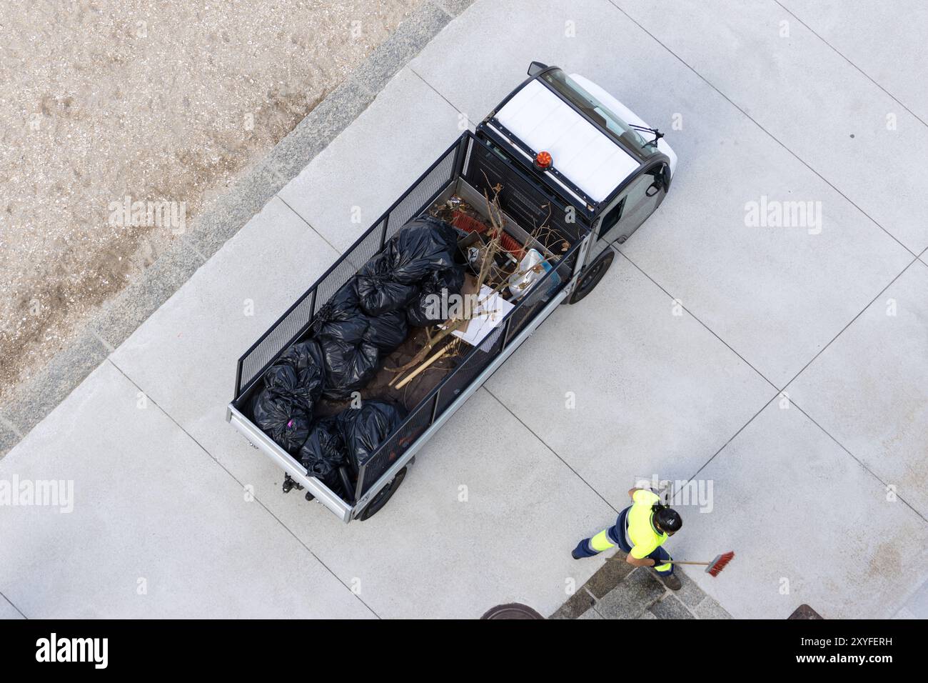 Aerial view of a Electric vehicle loaded with garbage bags and a street ...