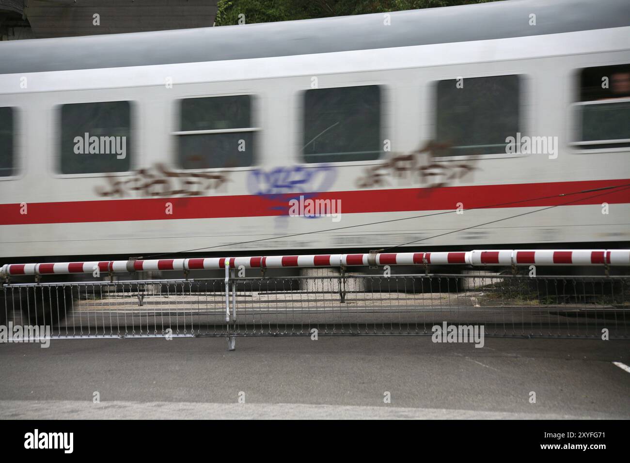 Rushing train with barrier Stock Photo - Alamy