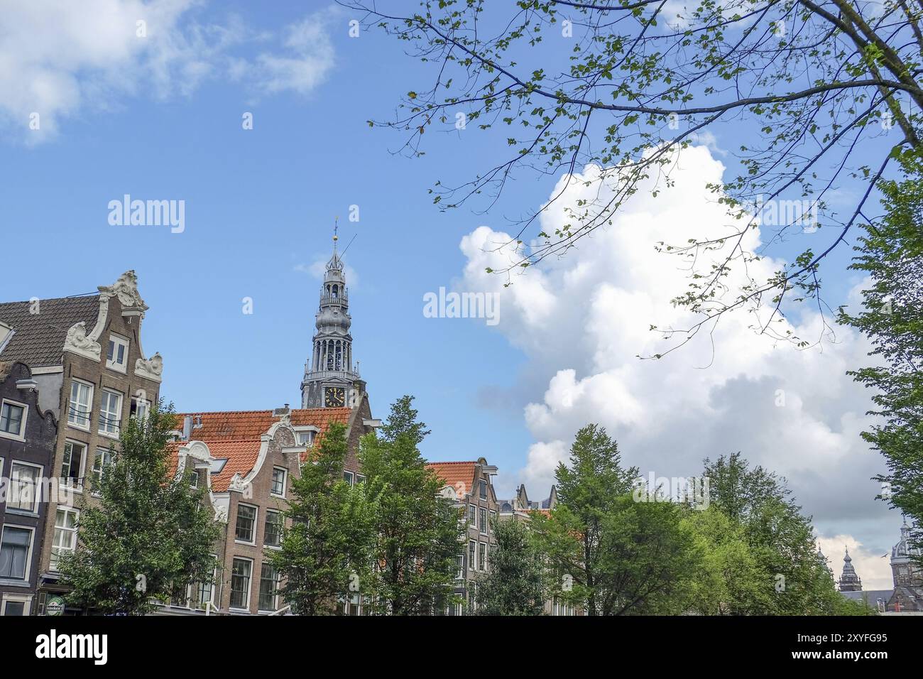 Historic gabled houses and a high church tower under a blue sky with ...