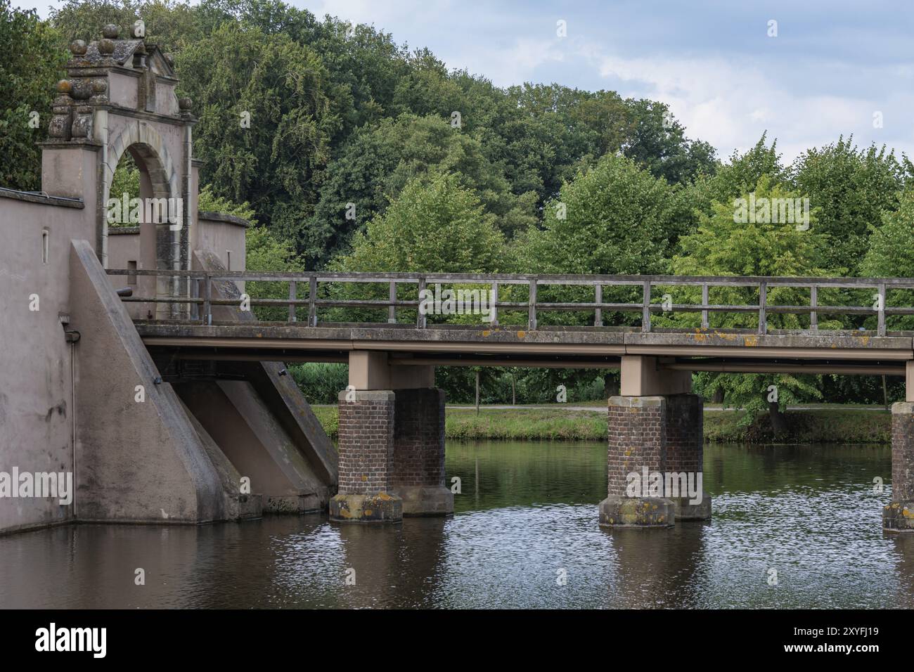 Stone bridge with arch over a river, surrounded by trees and nature ...