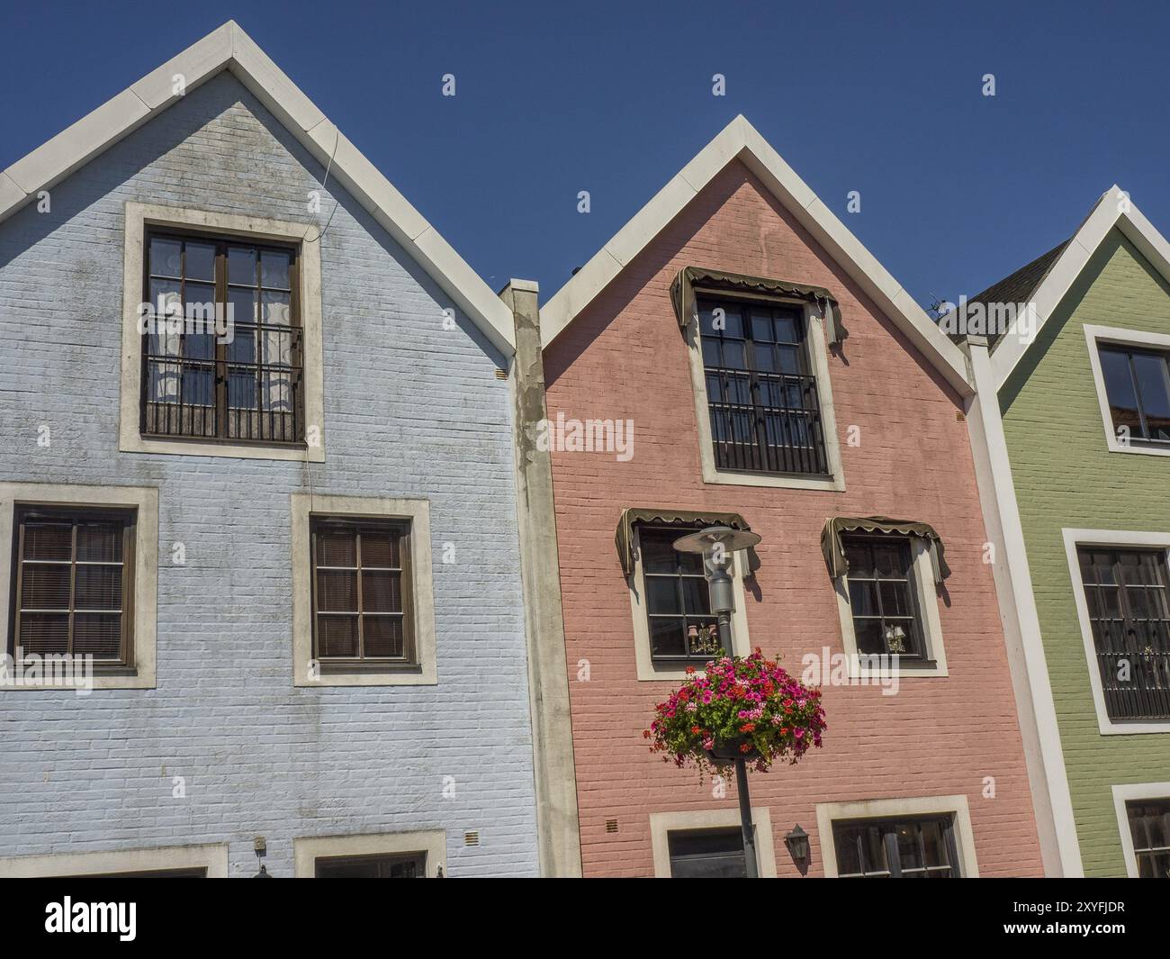 Colourful house facades in blue, pink and green with floral decorations ...