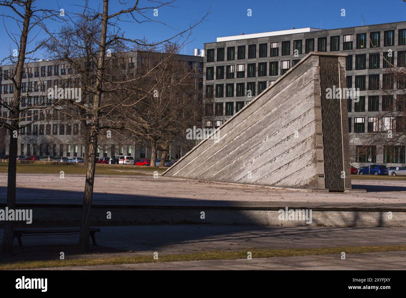 Stone wall plunging into the ground with buildings in the background ...