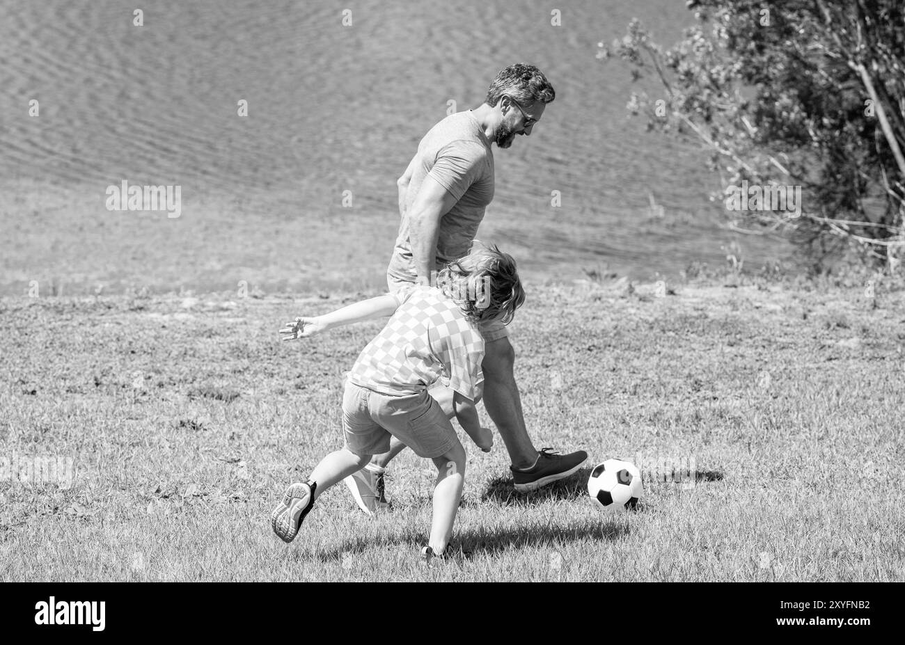 Father and son enjoy a friendly game of football. happy childhood of ...