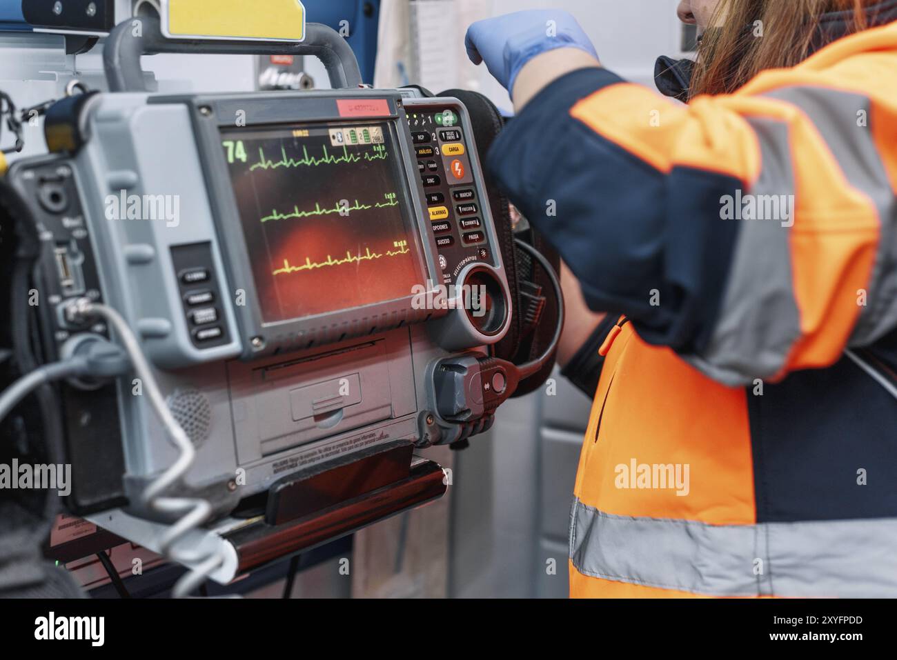 Medical urgency in the ambulance. Emergency doctor using defibrillator ...