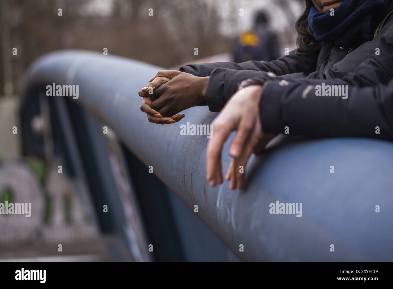 Two people place their hands relaxed on a railing Stock Photo - Alamy