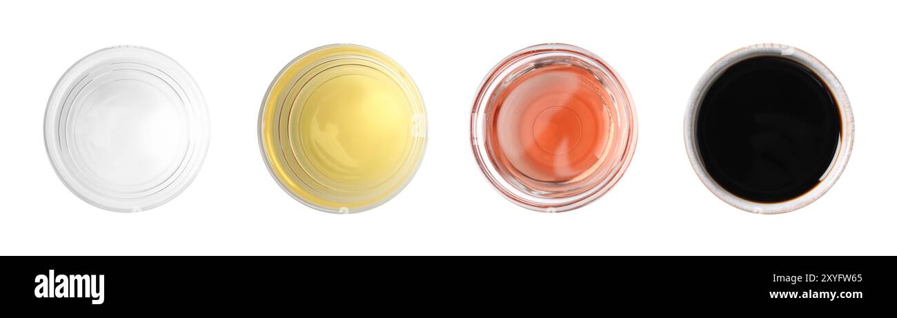 Different types of vinegar in glass bowls isolated on white, top view ...
