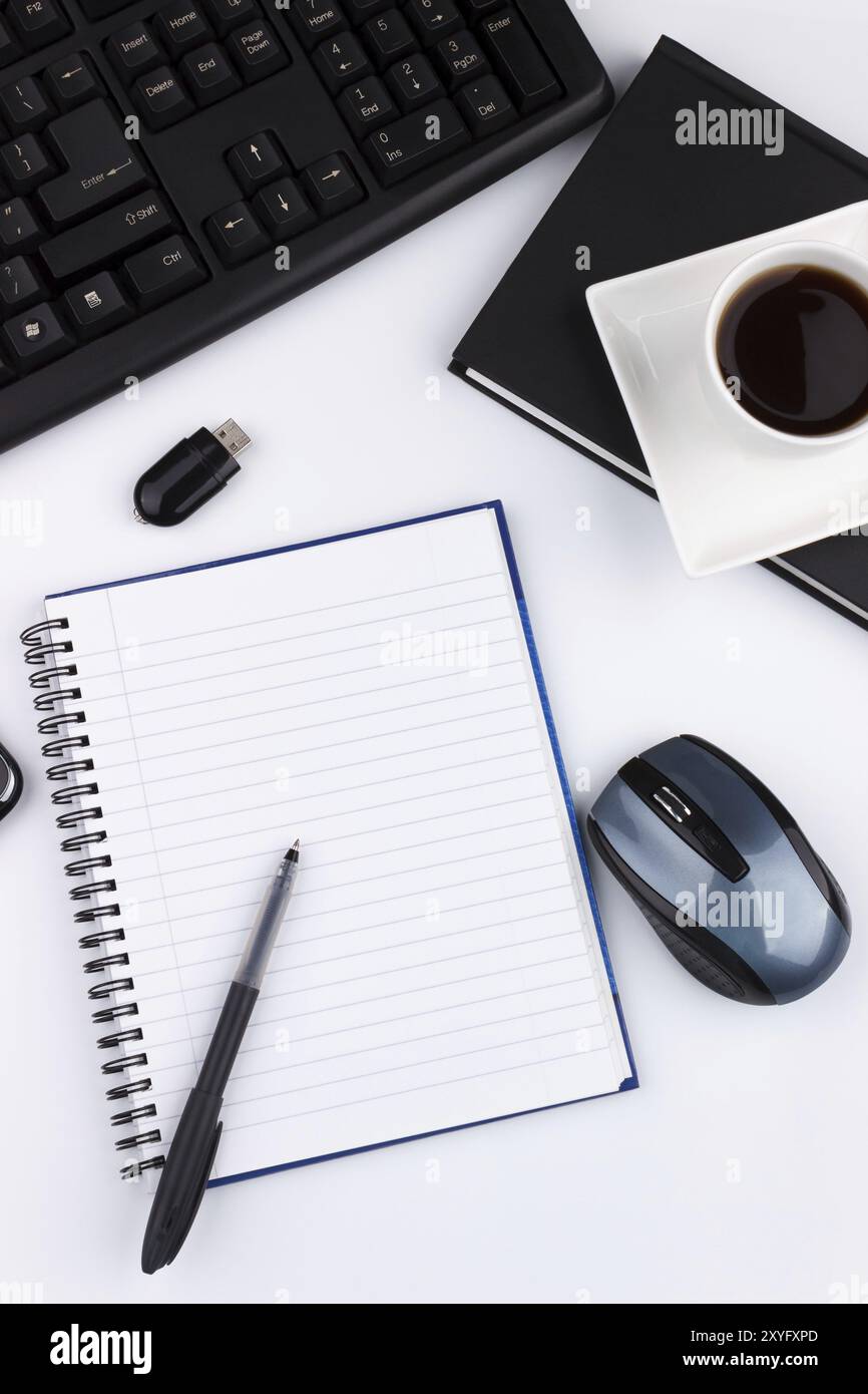 Overhead of office table with computer keyboard, mouse, USB, notepad ...