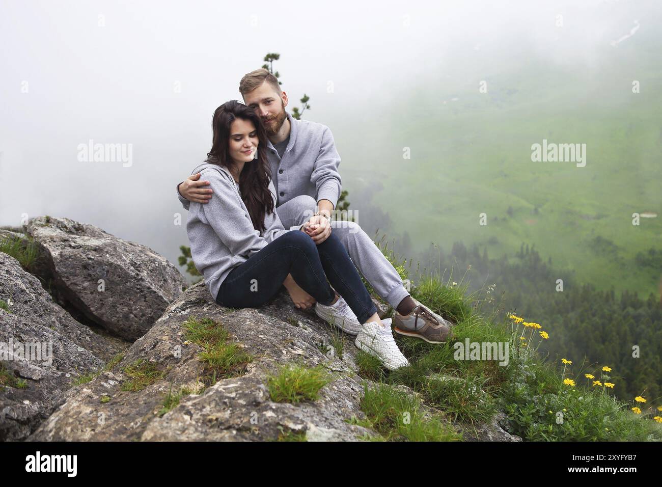 Young loving couple relaxing and hugging, she is smiling and leaning on ...
