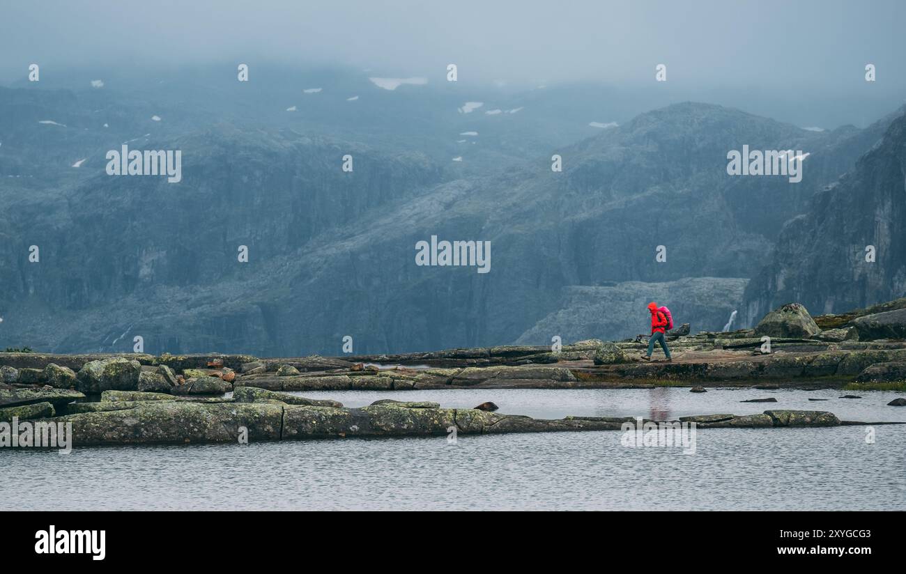 Woman trekker with backpack dressed bright red jacket enjoying famous ...