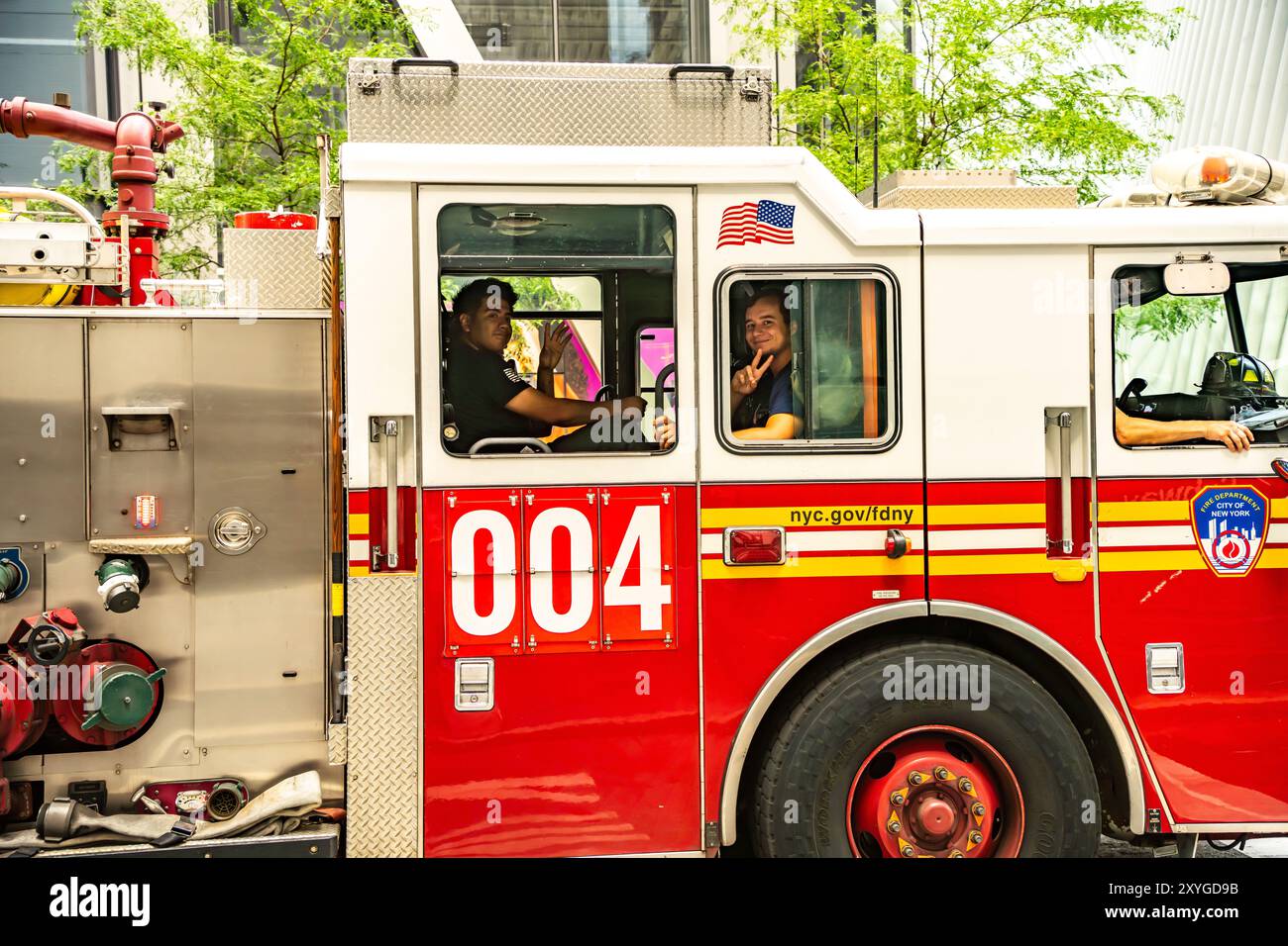 FDNY truck with young fire fighters in downtown New York ready to go ...