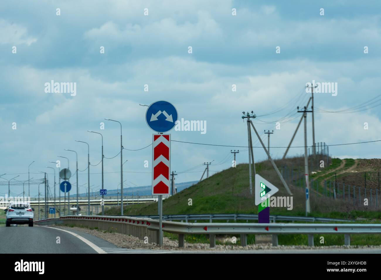 A road with a blue sign that says "Do not enter" and a red arrow ...