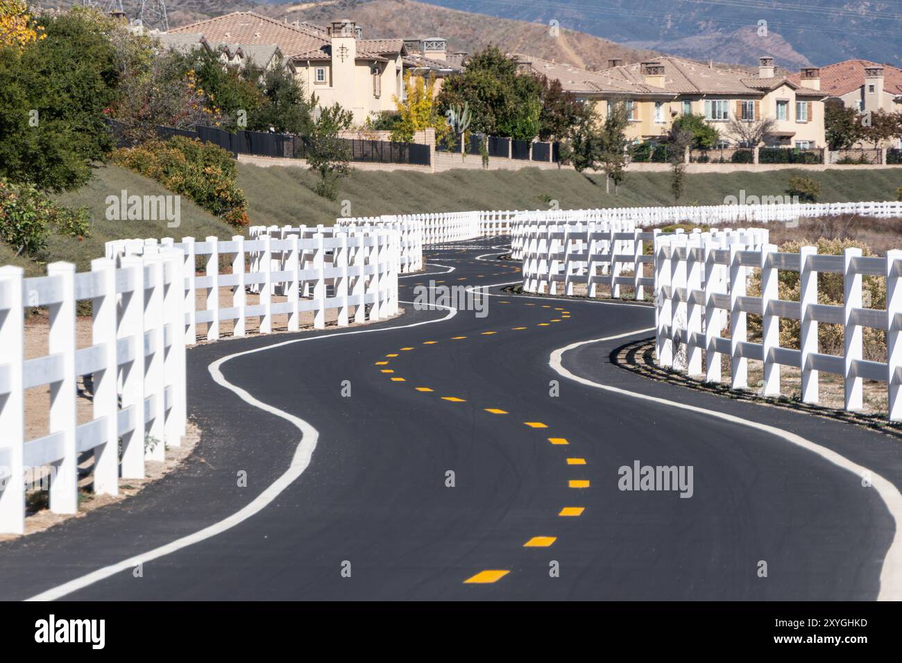 Suburban bike path with white fencing entertaining wiggles along the ...
