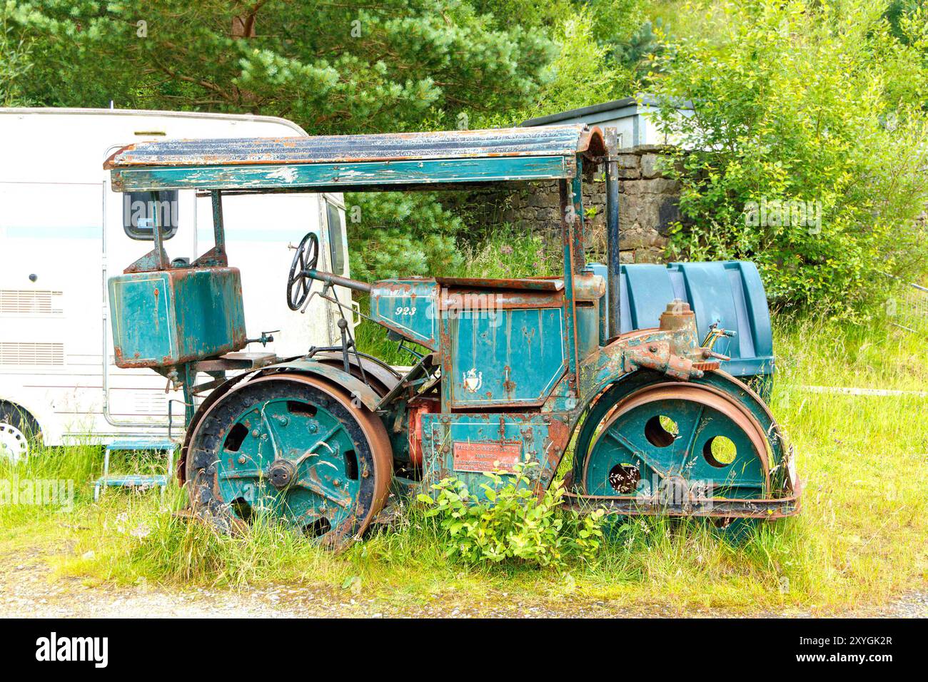 An old,orusted vintage steam roller tractor with a blue and green color ...