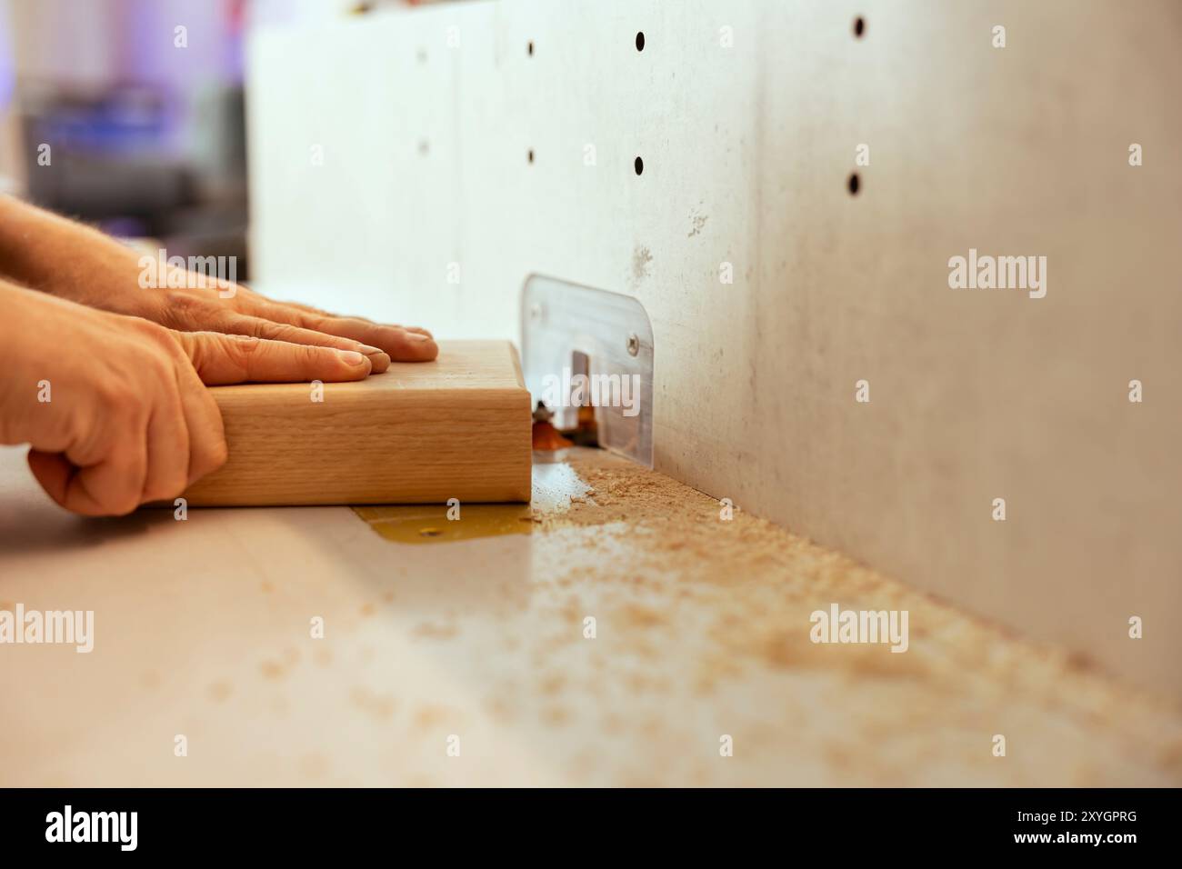 Man using wood shaper machinery to finish customer commissioned work on ...