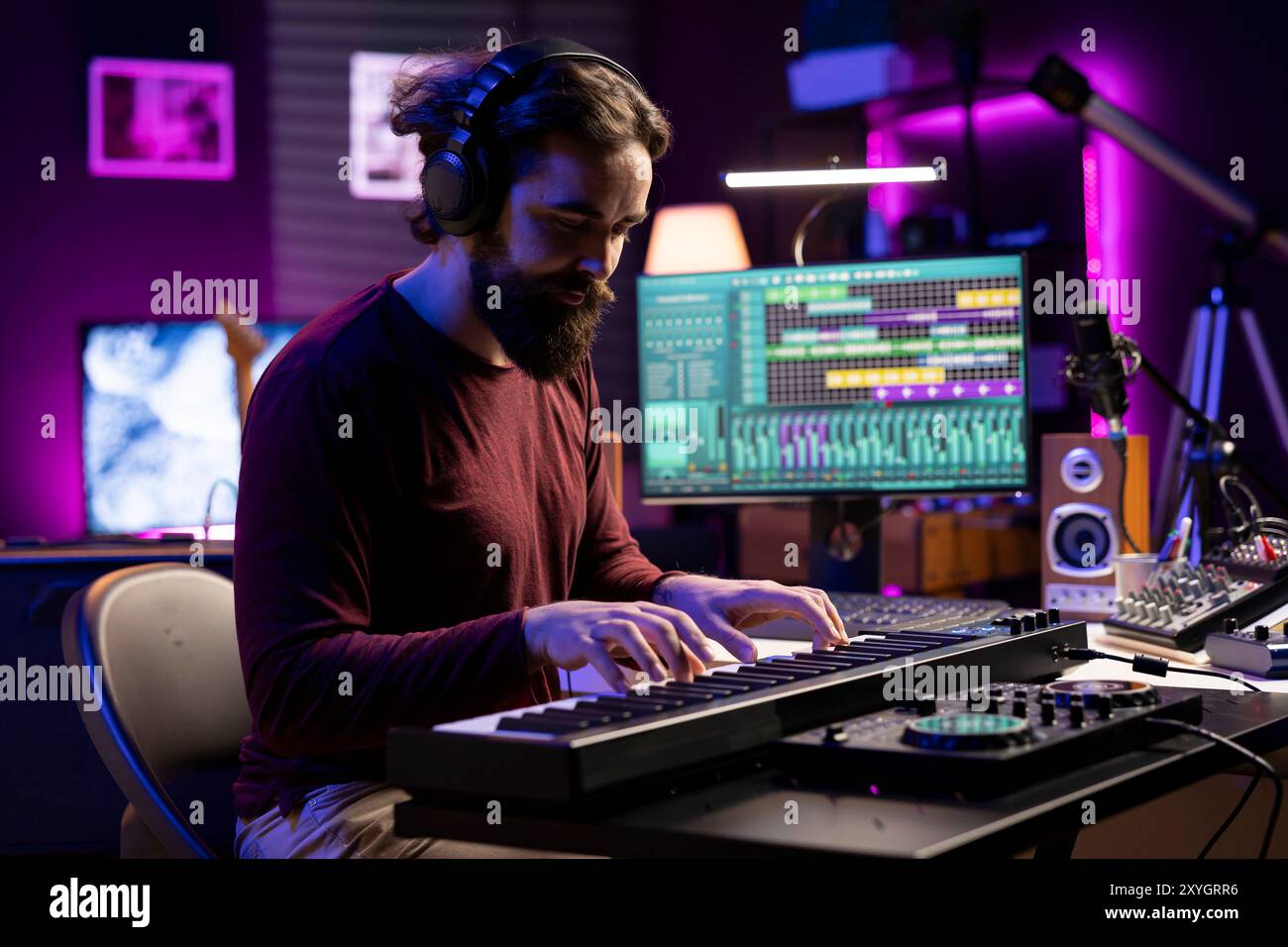 Musician playing electronic keyboard piano in his home studio, using ...