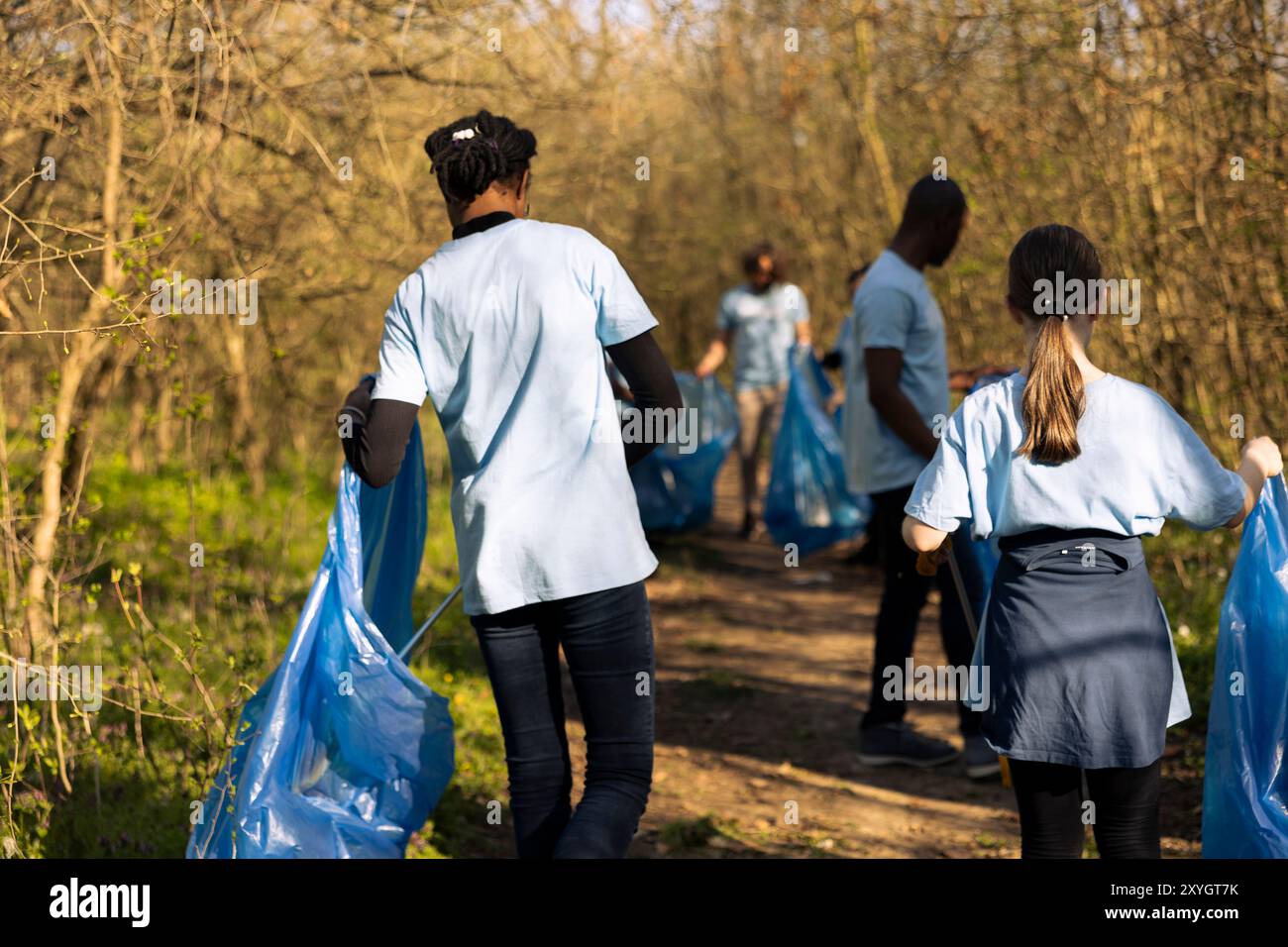 African american girl working with a team of ecologists to collect junk ...