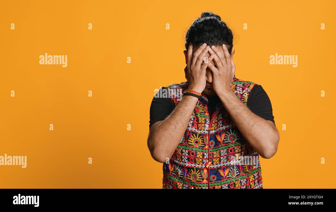 Indian man covering face with palms in disbelief, feeling upset by ...