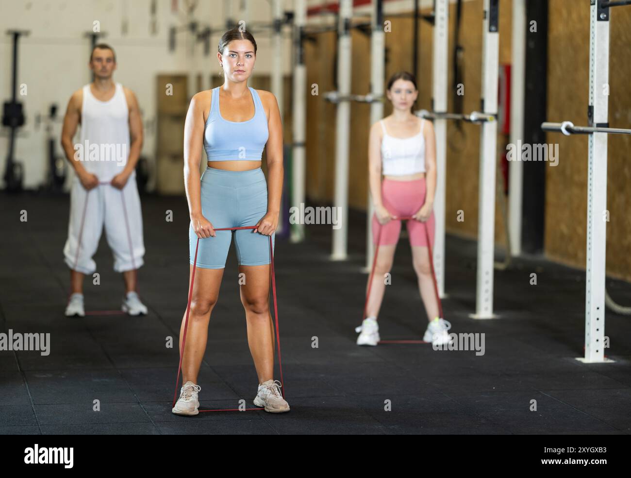 Young girl working out with other athletes with resistance band, strong ...