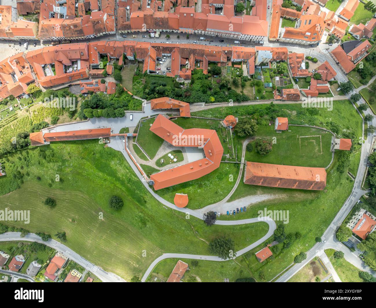 Aerial top down view of medieval Ptuj castle with red roof on the green ...