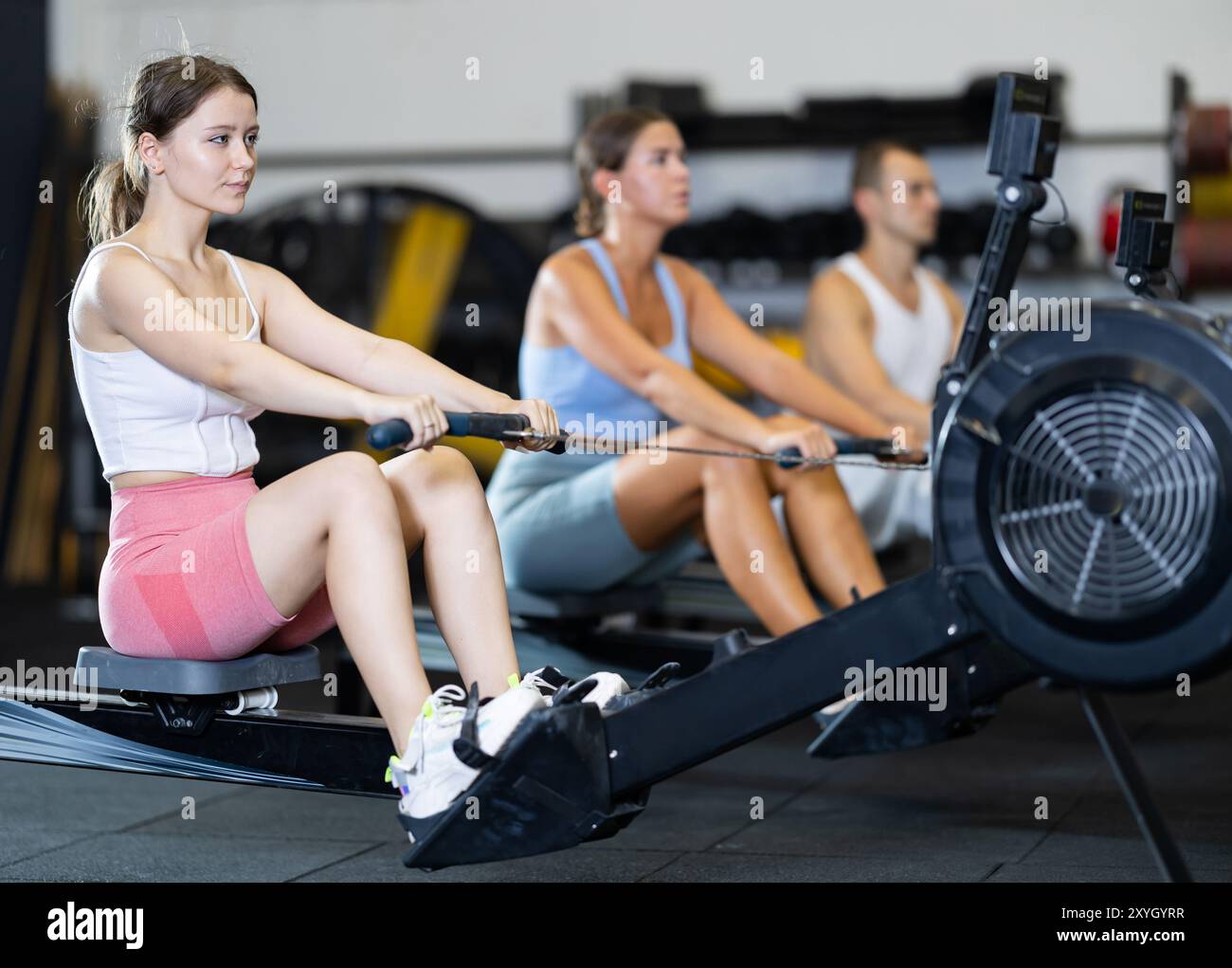 Young woman exercising rowing machine hi-res stock photography and ...