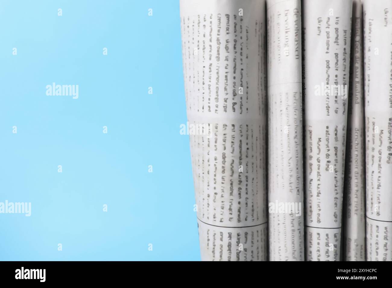 Many newspapers in different languages on light blue background ...