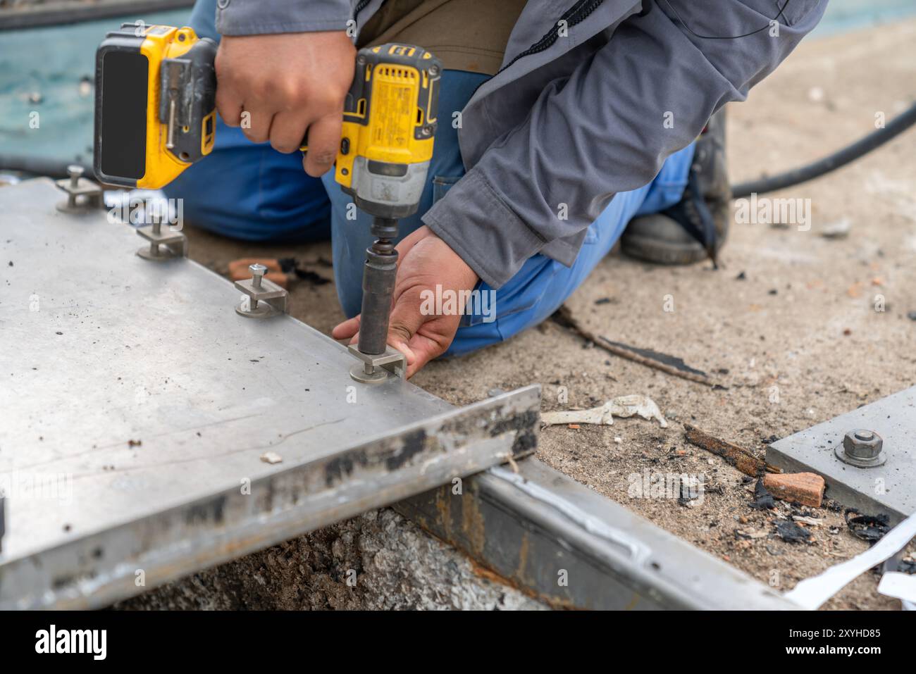 Close up worker use cordless block head tighten clamp nut cover pit in ...