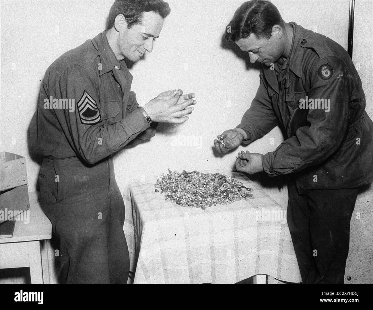 Two american soldiers ooking at some of the gold fillings found in ...
