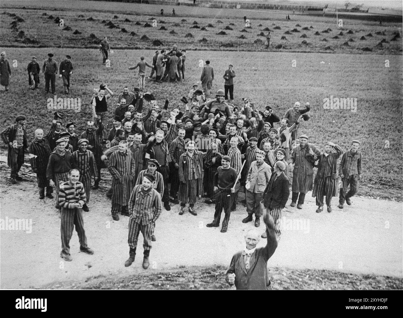 Survivors in waving to US troop as they enter Dachau after liberation ...