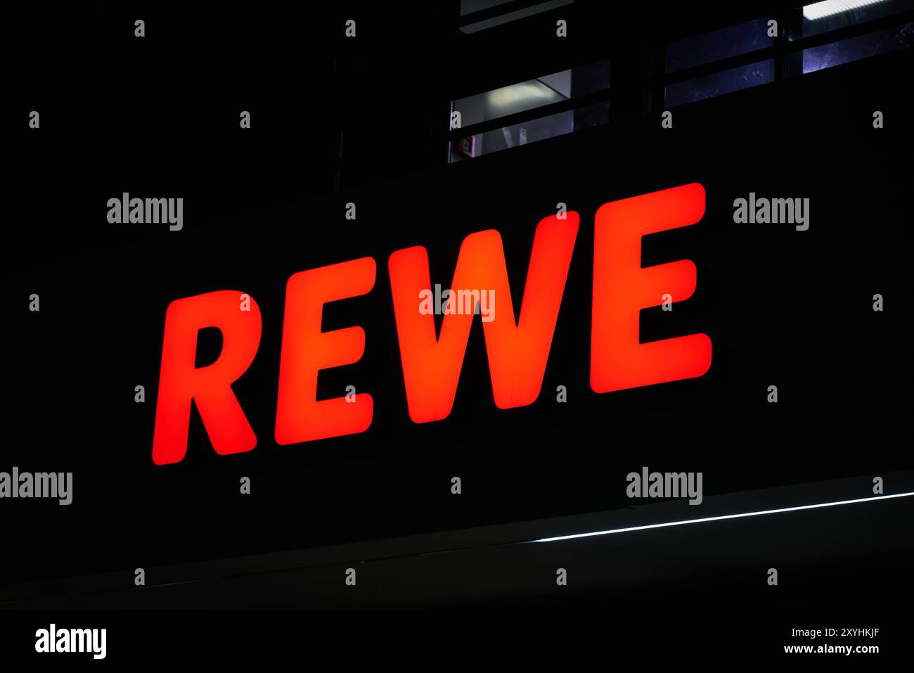 Illuminated advertisement of the German food retailer Rewe at a Rewe ...
