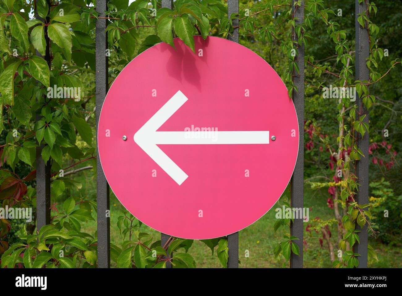 Sign with an arrow pointing left on a fence, indicating the right ...