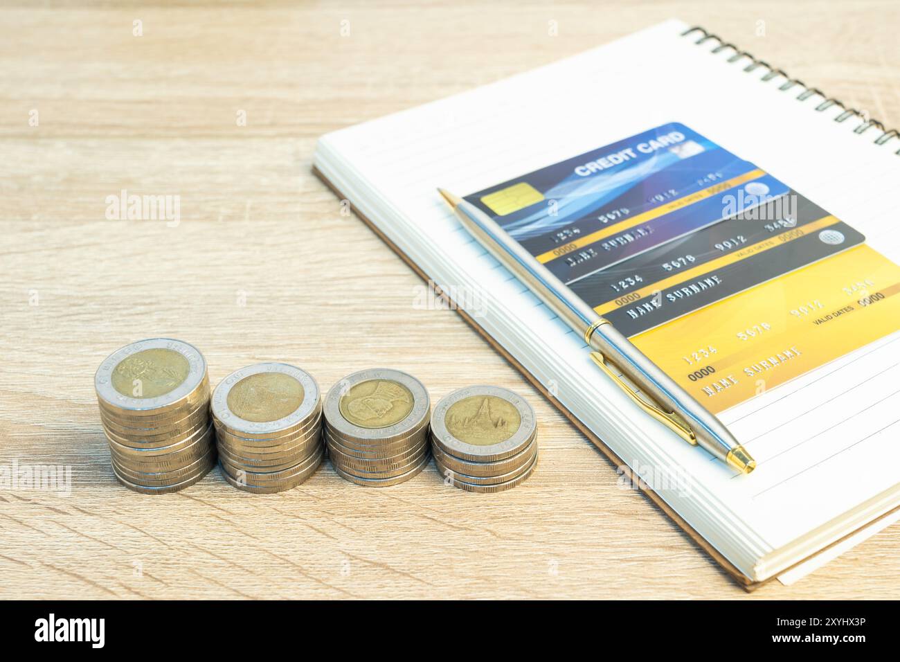 Top view coins with note pad and credit card on wood table using as ...