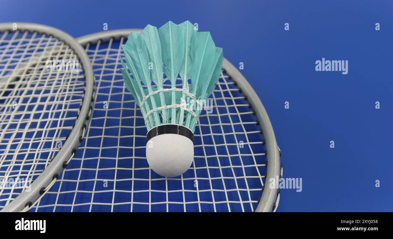 Yellow badminton feather shuttlecock on badminton racket over a blue ...
