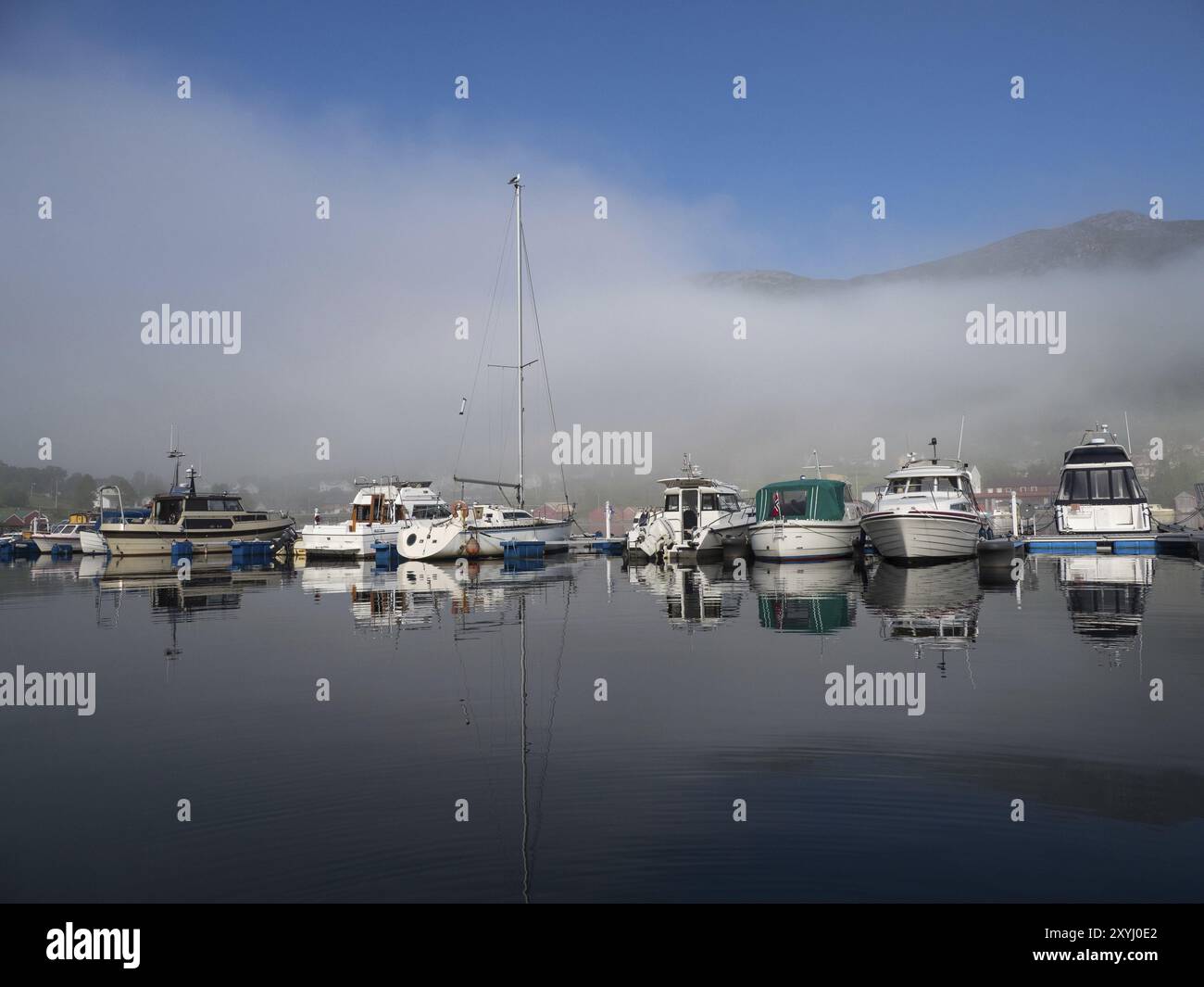 In the harbour of Hareid in Norway, the boats are reflected in the ...