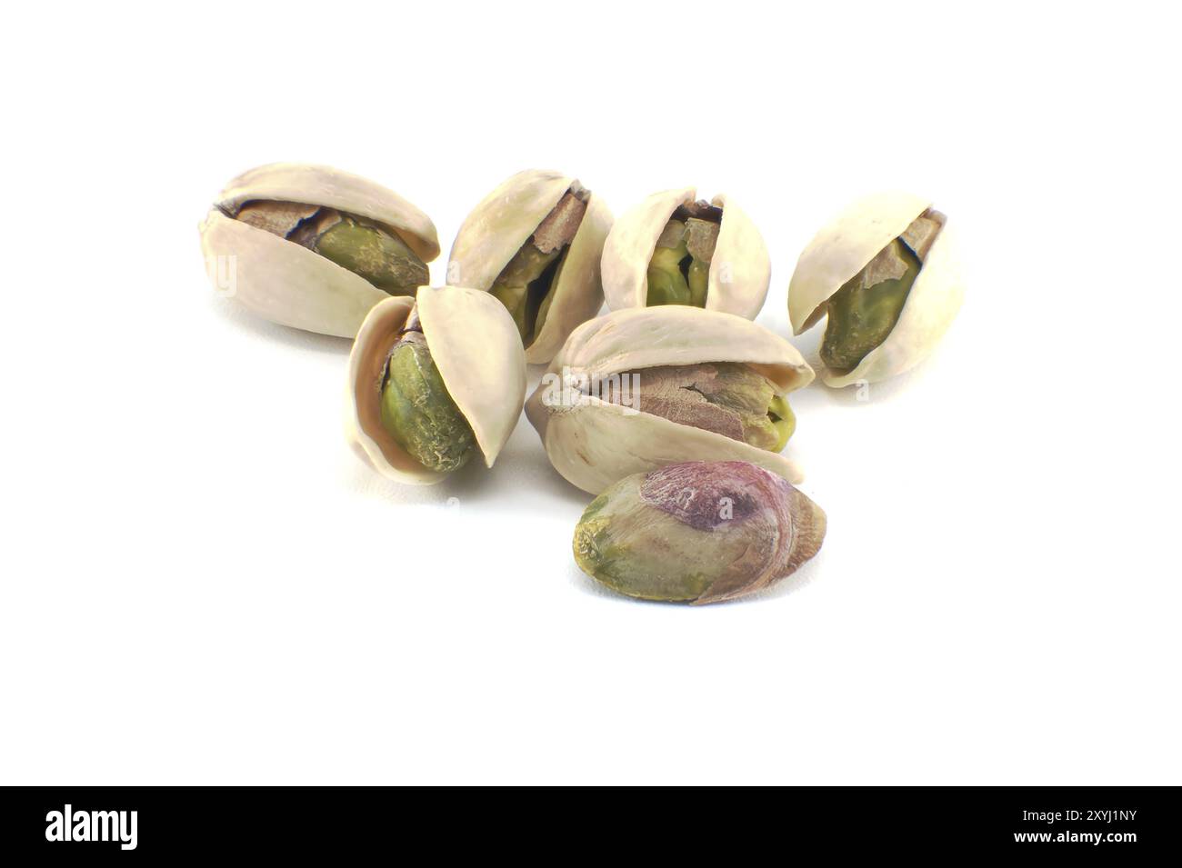 Pistachios in-shell and others peeled exposing the green nuts inside ...