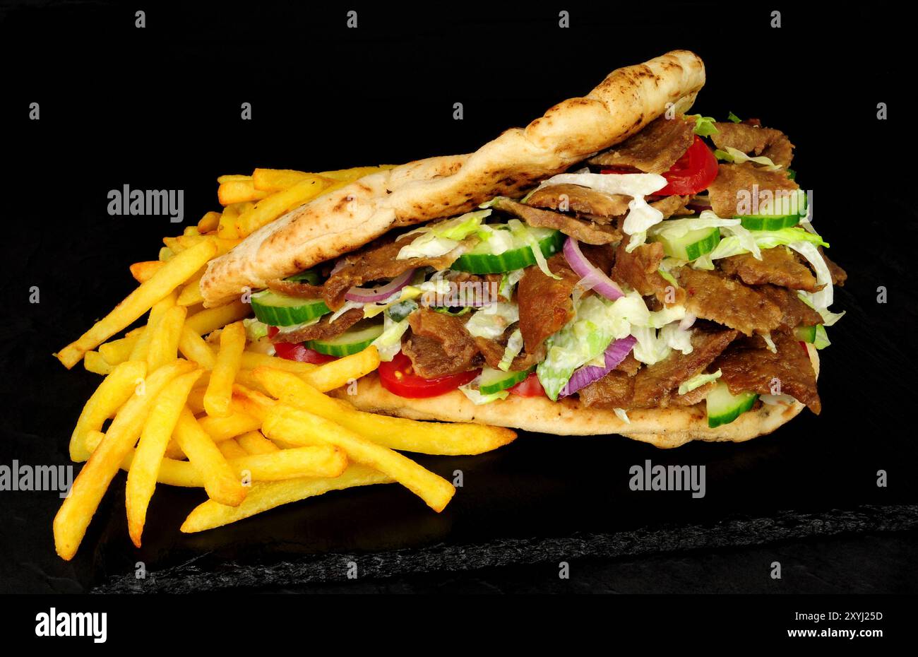 Doner kebab meat and French fries in a naan bread with salad Stock ...