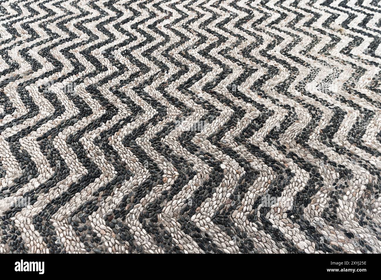 Mosaic ground pavement with striped pattern of black and white pebble ...