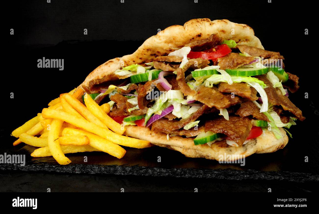 Doner kebab meat and French fries in a naan bread with salad Stock ...