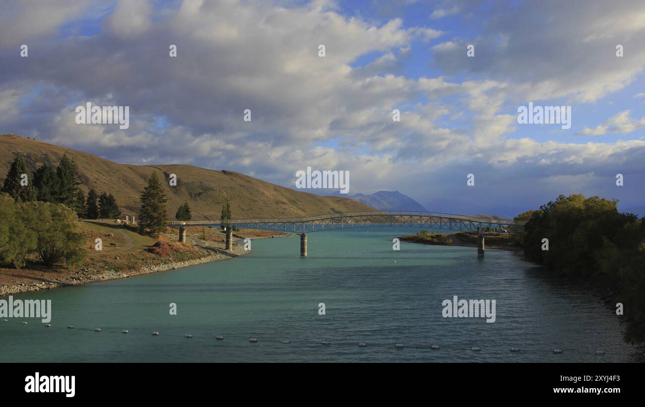 Scene in Canterbury, New Zealand. Bridge over turquoise Tekapo River ...