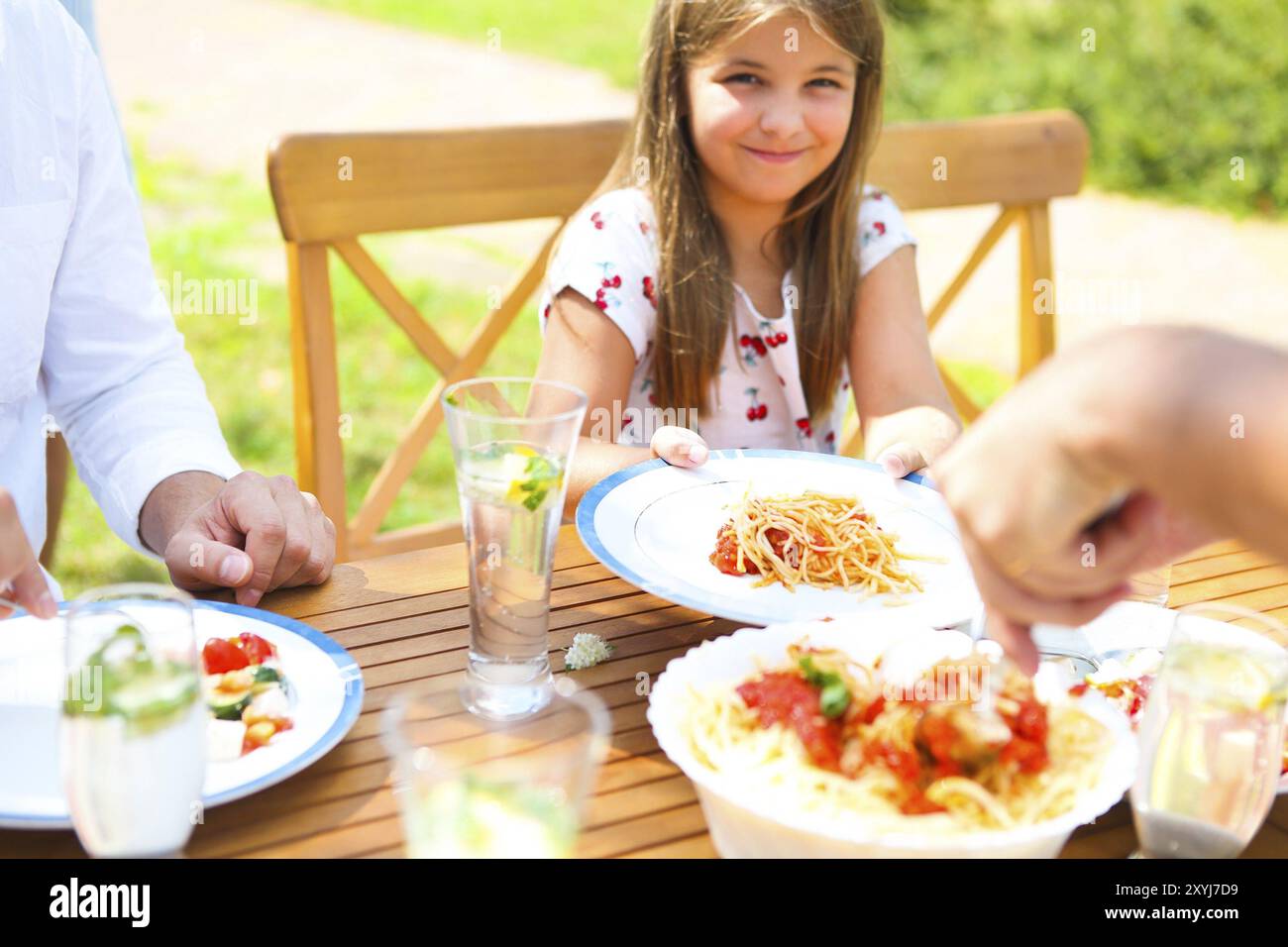 Family dinner variety of Italian dishes on wooden table in the garden ...