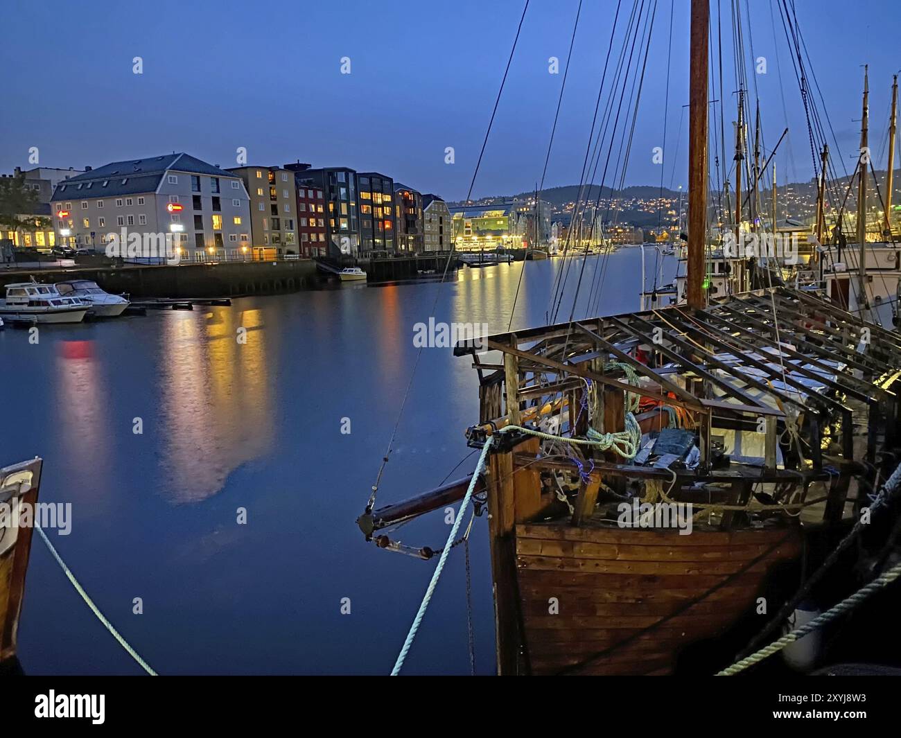 Harbour at night with illuminated boats and modern buildings in the ...