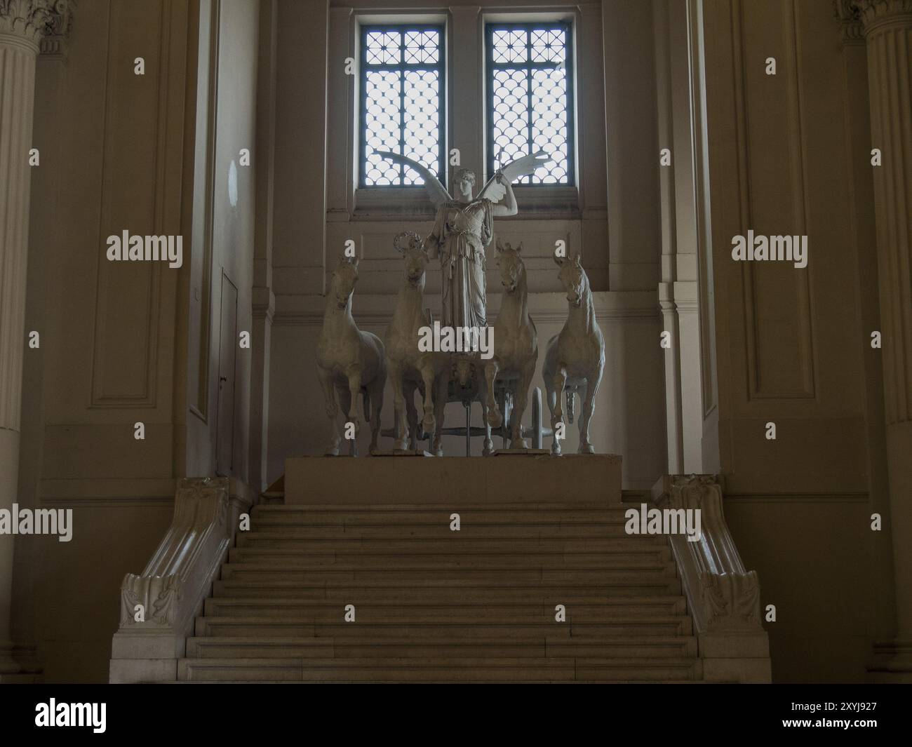 A large statue of four horses and an angel on a staircase in an ...