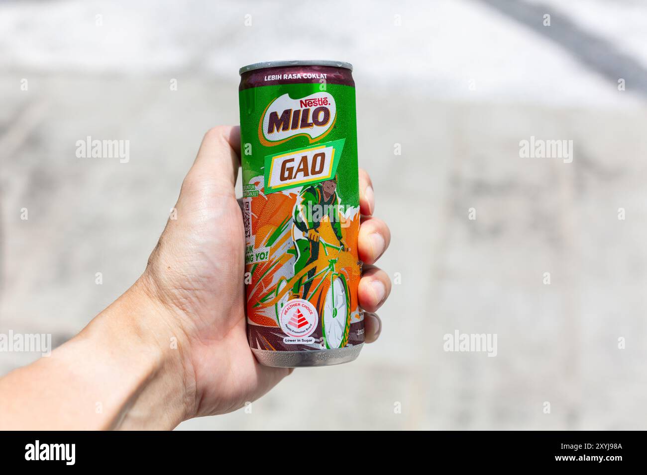 Hand holding a can of Nestlé Milo Gao drink against white wall ...